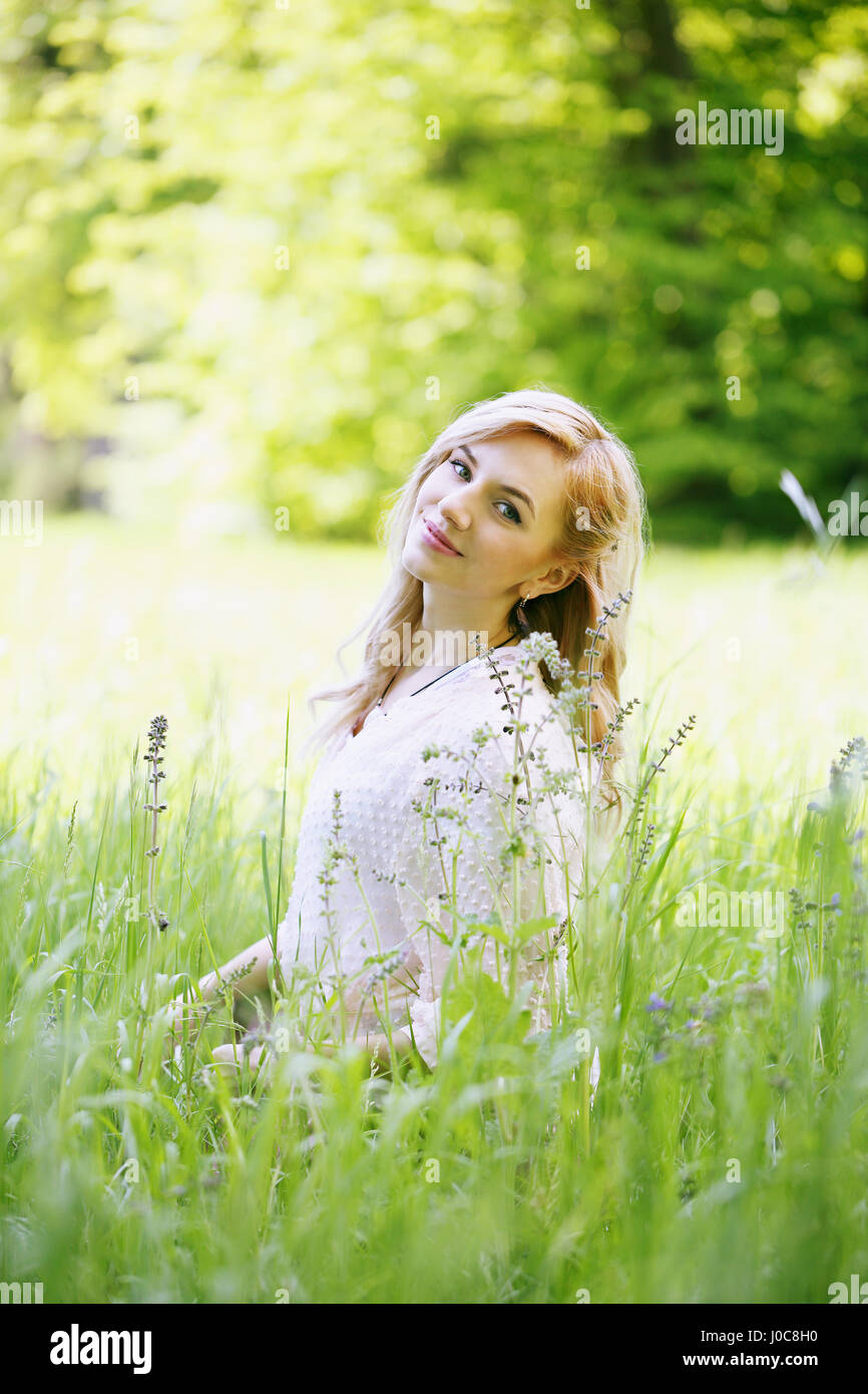 beautiful girl sitting in the grass Stock Photo - Alamy