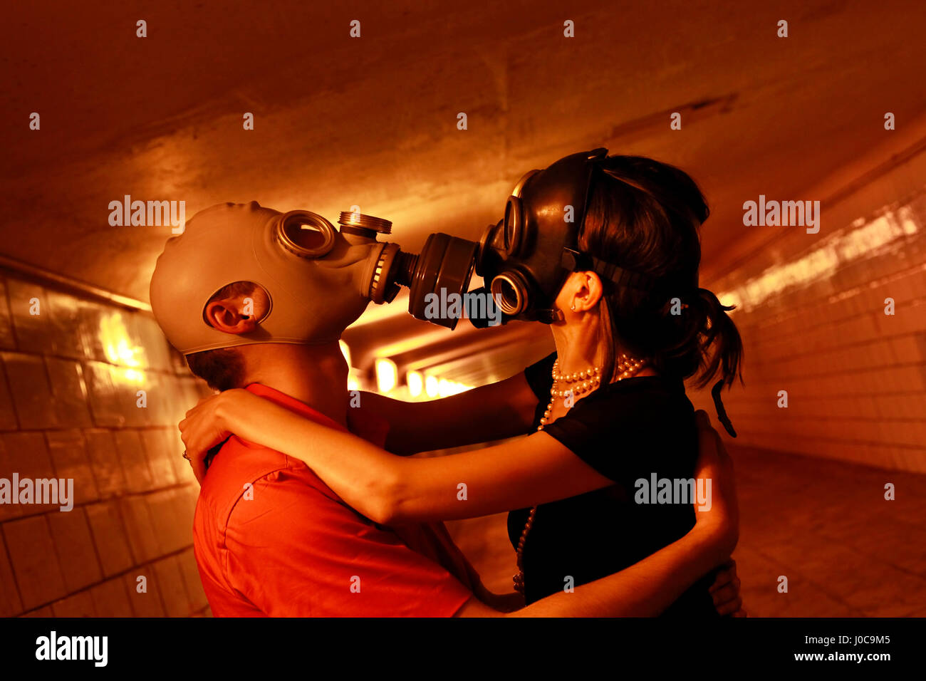 Married couple in gas masks in a tunnel Stock Photo - Alamy