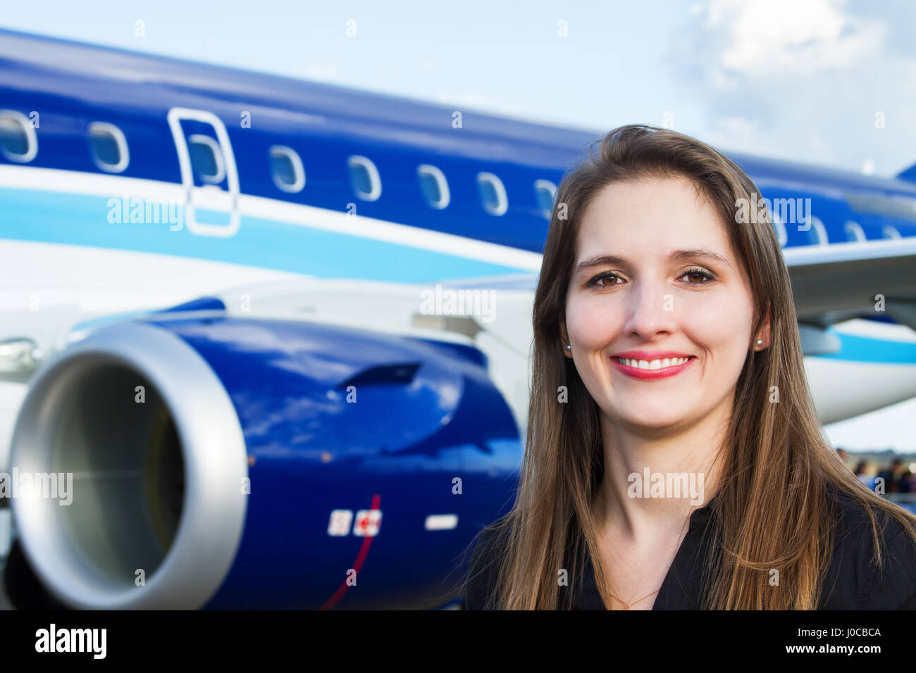 Beautiful business woman smiling in front of an jet airplane Stock ...