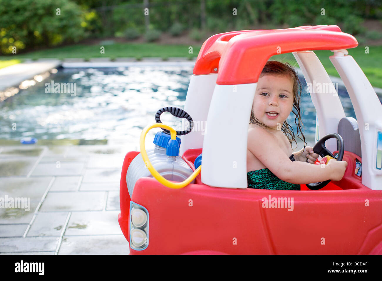 Cute girl playing driving car hi-res stock photography and images - Alamy
