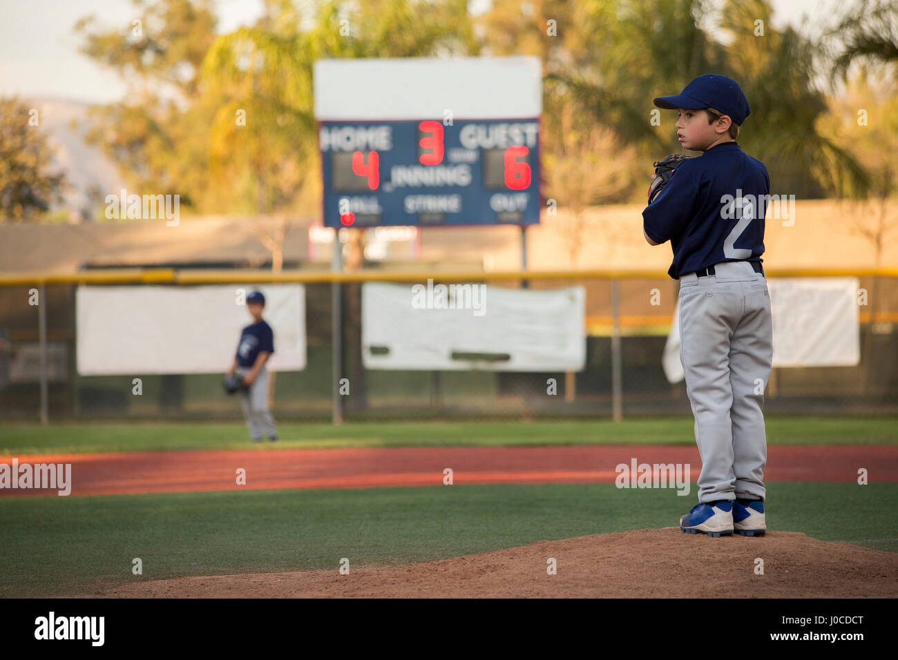 Boy baseball pitcher preparing to throw on baseball field Stock Photo ...