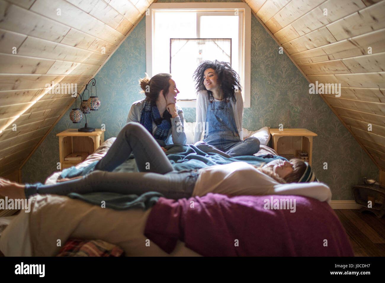 Three female friends, relaxing in bedroom Stock Photo - Alamy