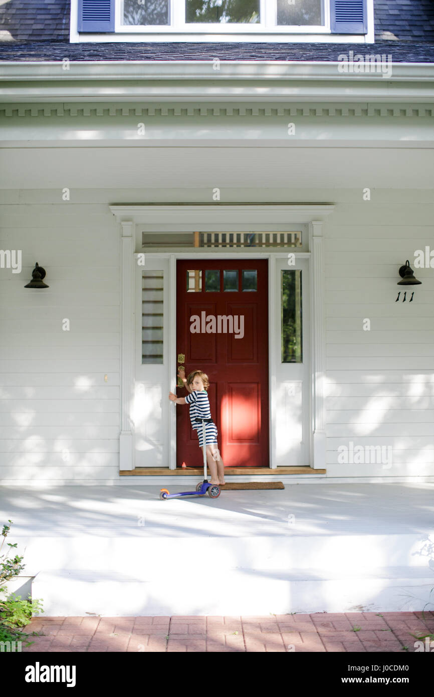 Portrait of boy on porch with push scooter Stock Photo - Alamy