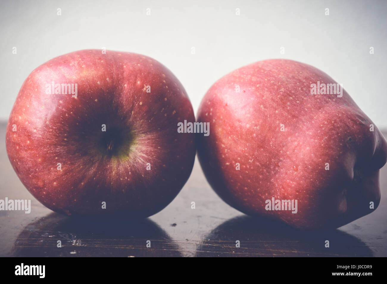 two red apples on wooden table Stock Photo - Alamy