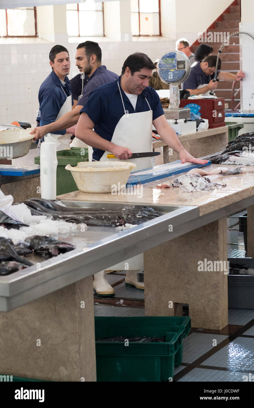 A fishmonger prepares a black scabbard fish into fillets for sale at ...