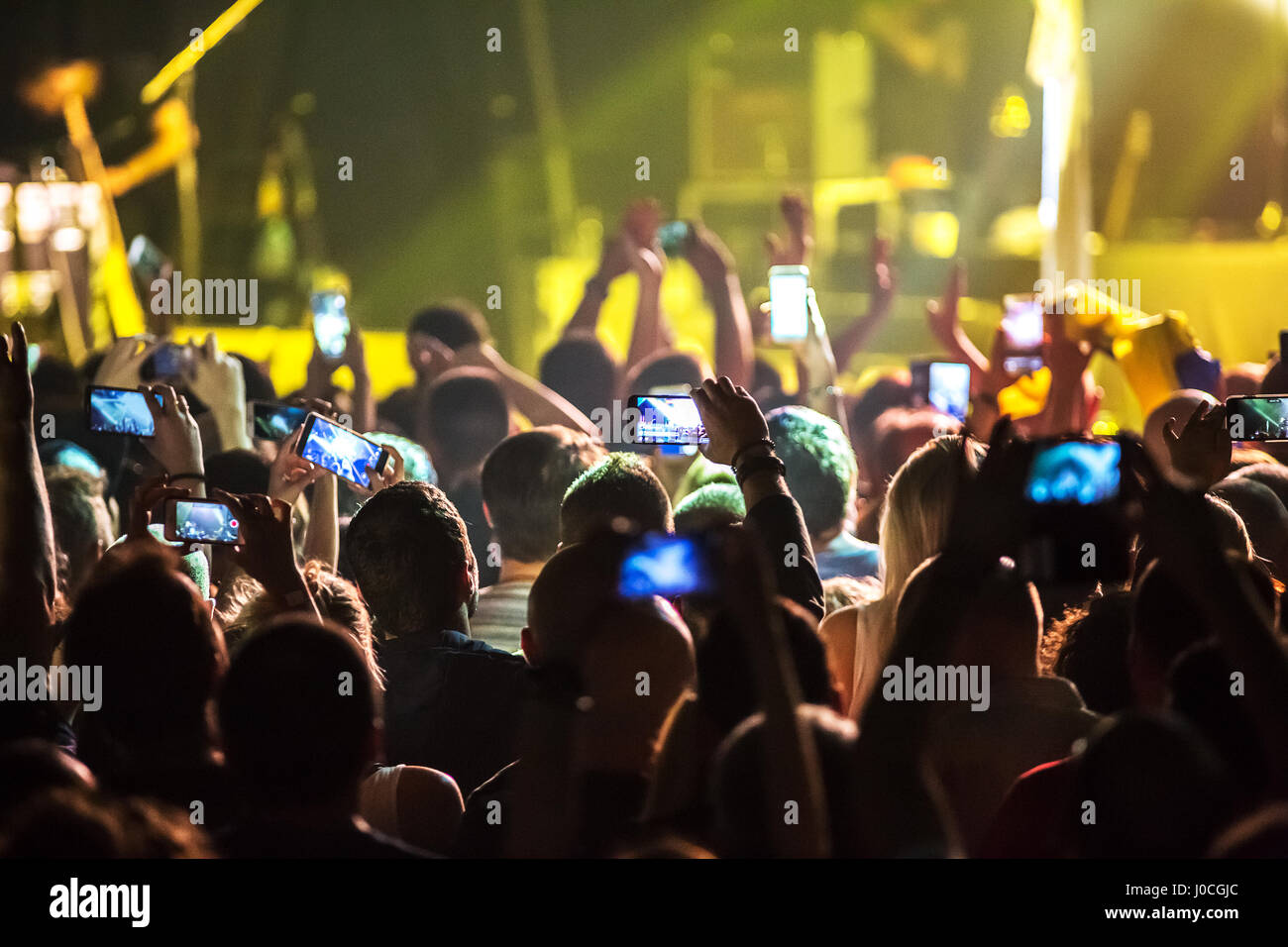 Crowd at concert and blurred stage lights . Close up of photographing ...