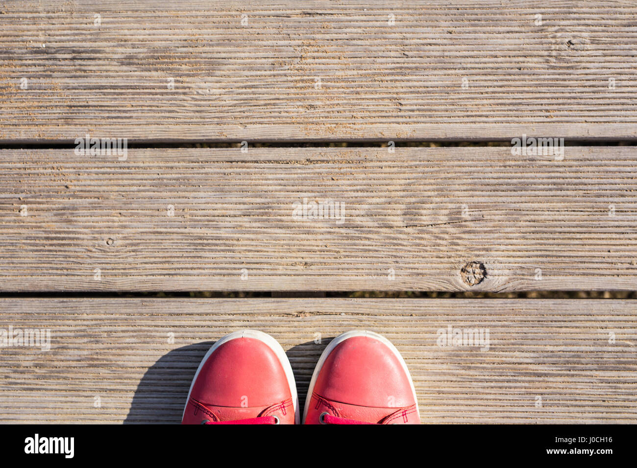 Feet in casual pink shoes on the wooden pier background Stock Photo - Alamy