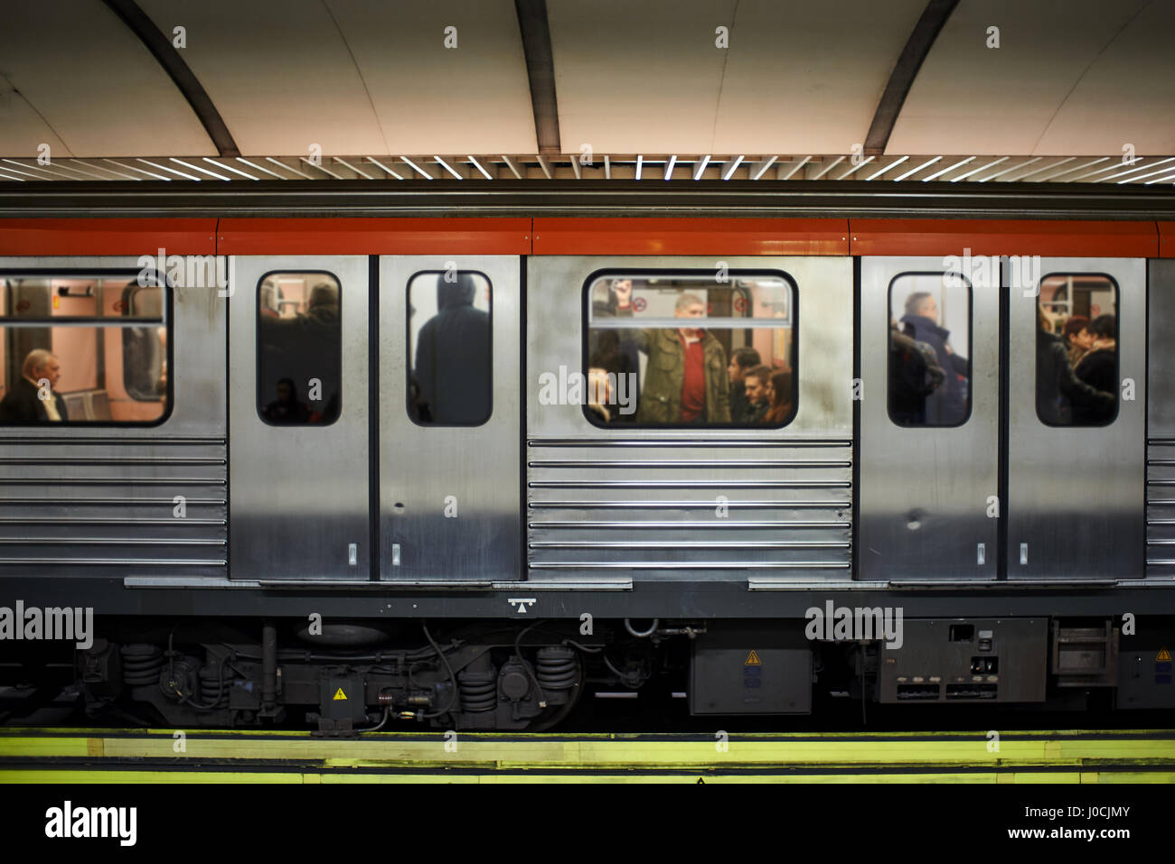 Metro train waiting in the station with passengers Stock Photo - Alamy