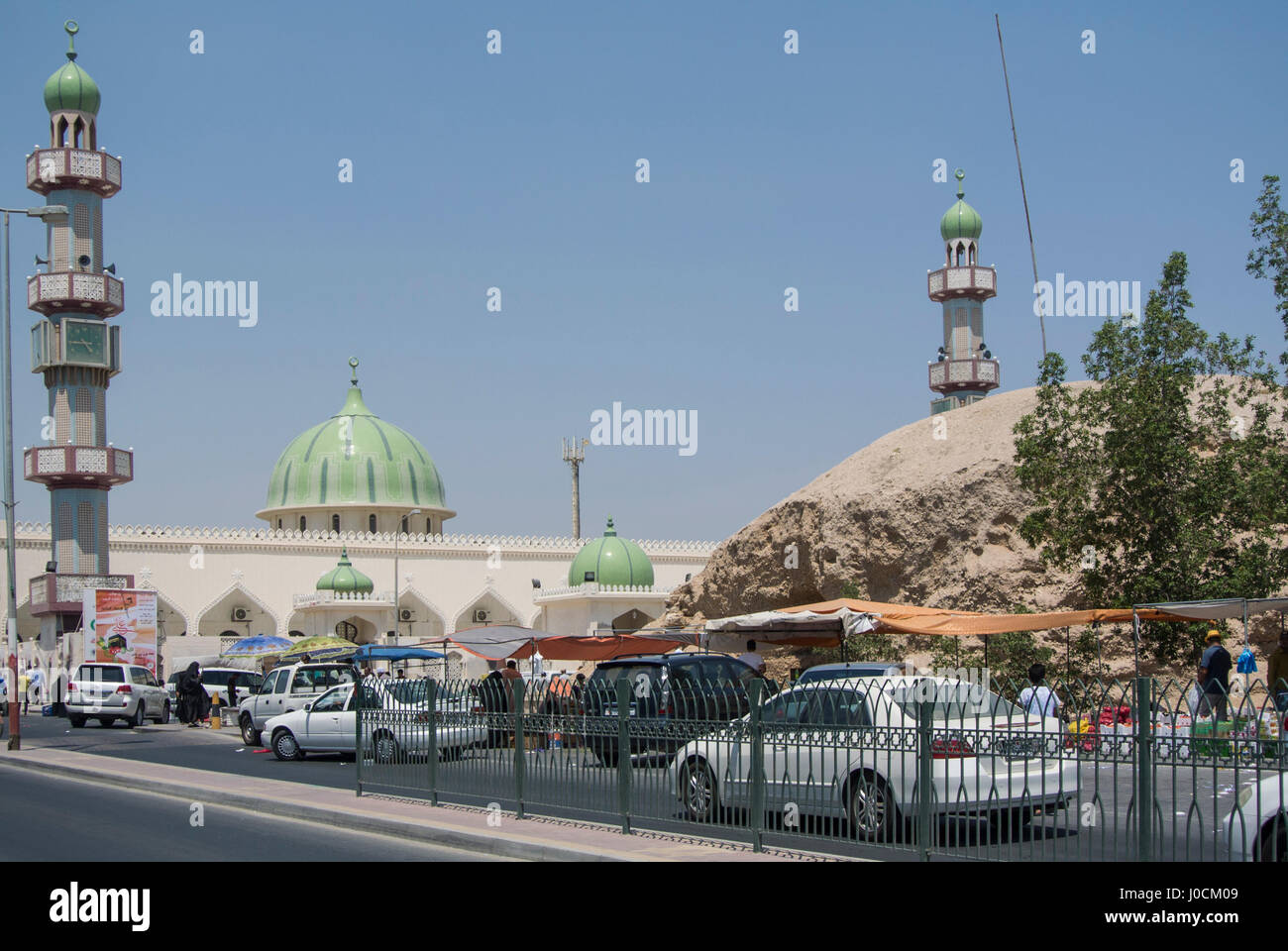 Traffic adjacent to a burieal mound near a mosque, A'ali, Bahrain Stock ...