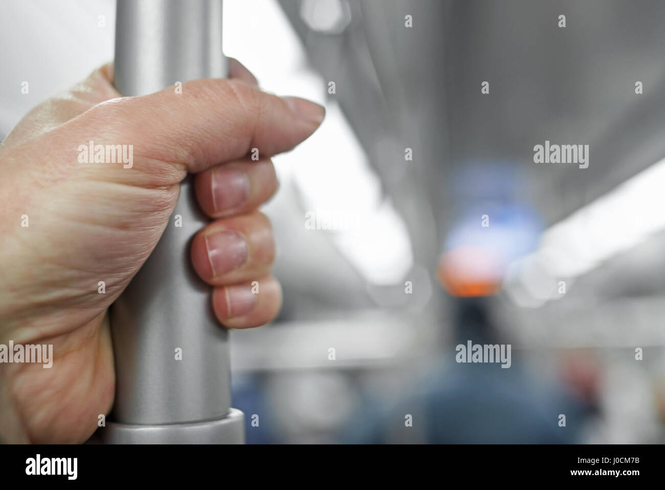 Hand holding a steel beam. Standing passenger inside metro train Stock ...