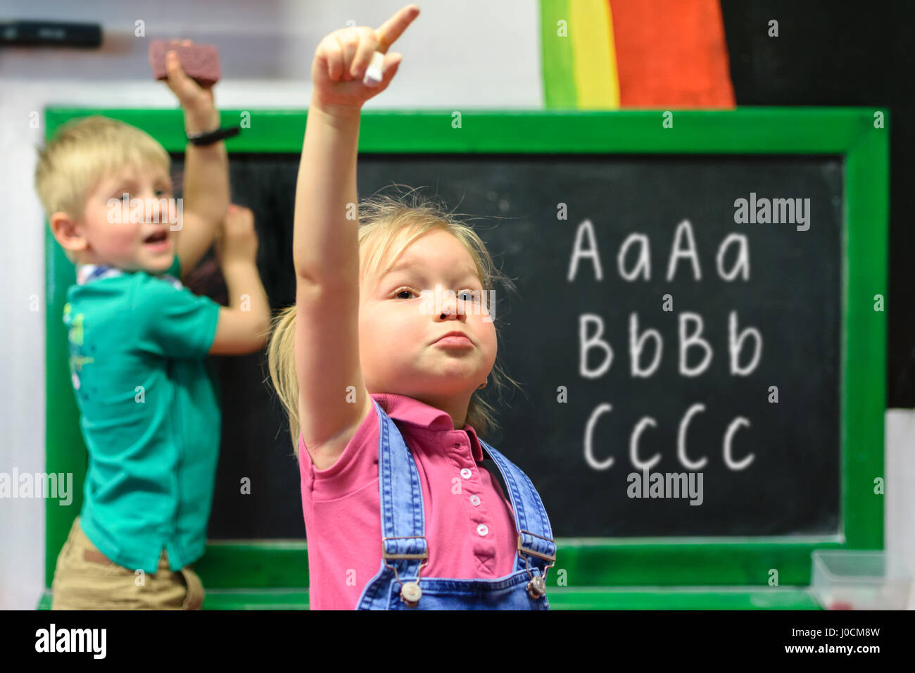 Beautiful little girl and boy learn to write on the blackboard in ...