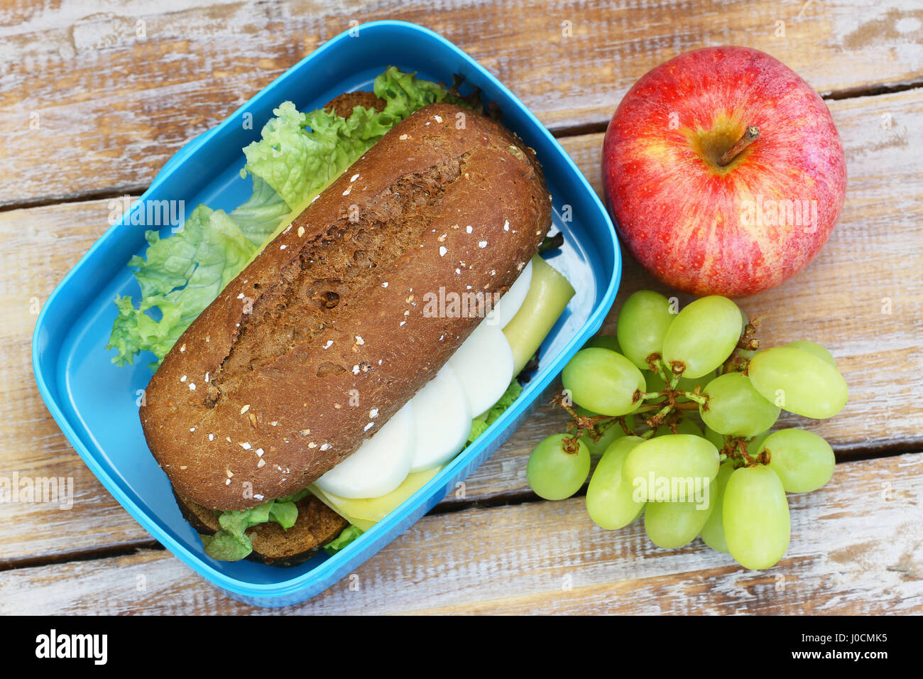 Healthy lunch box containing brown roll with cheese and egg and fresh ...