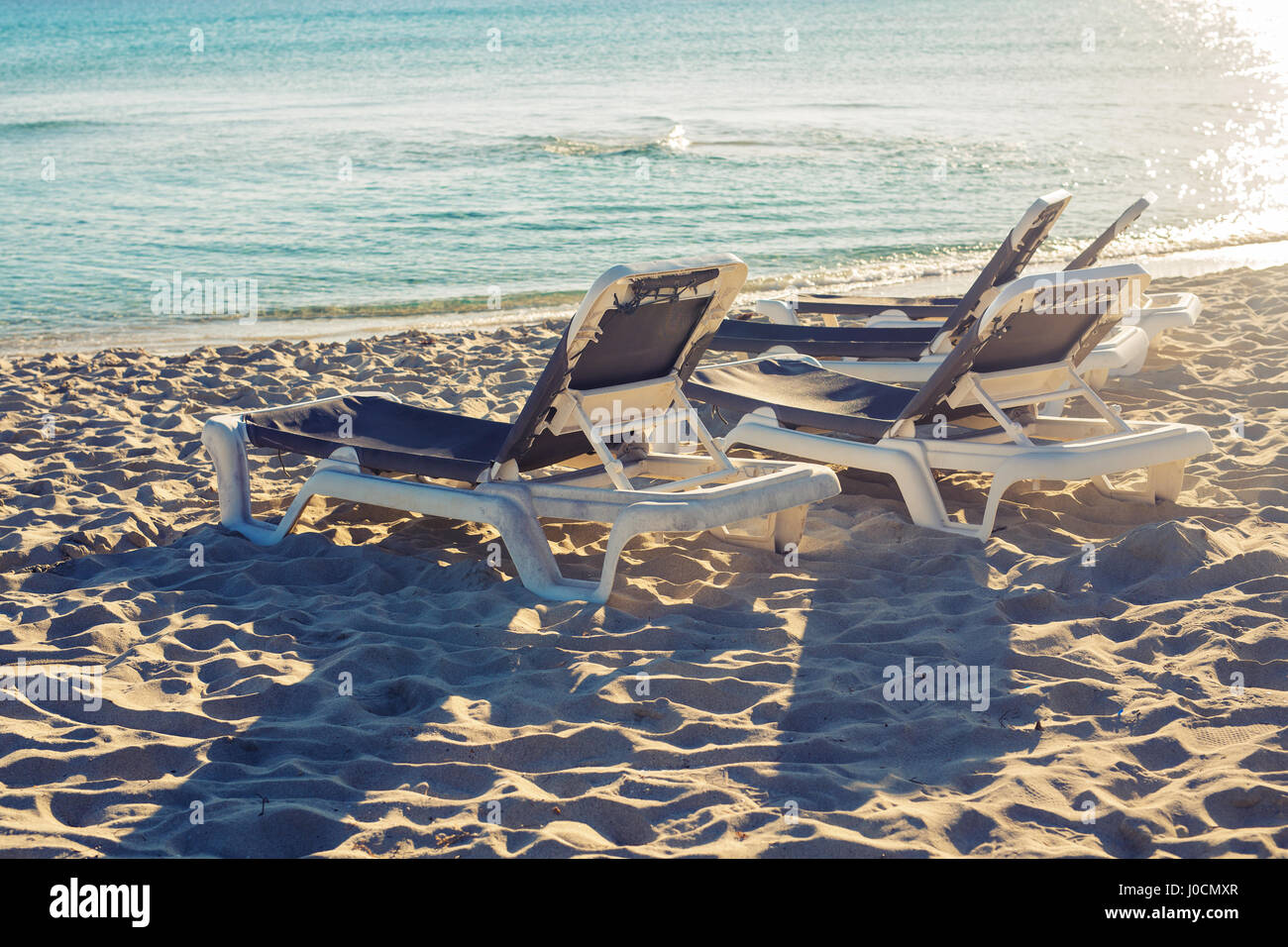Sunbeds on the sea beach during sunset Stock Photo - Alamy