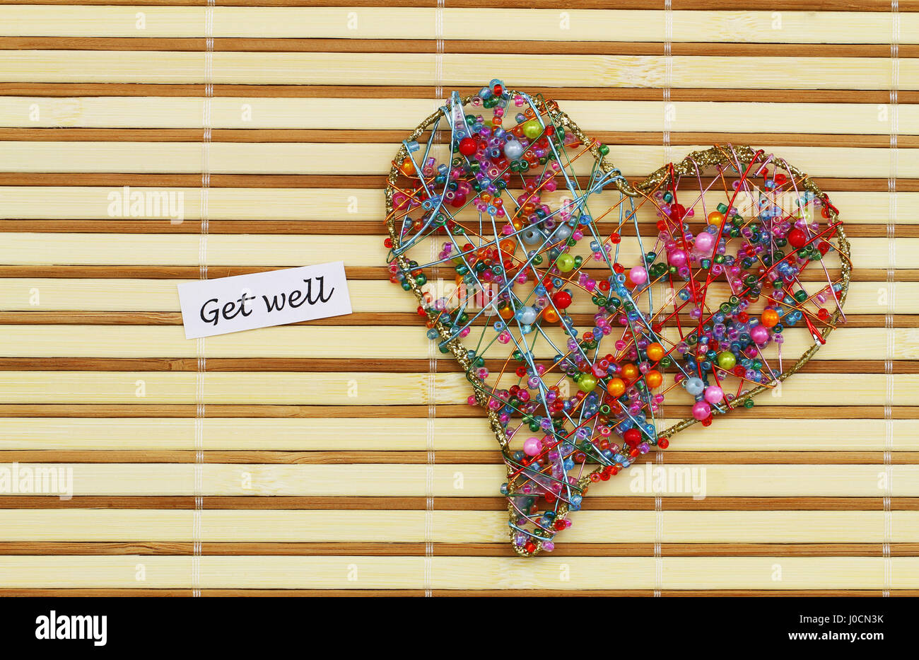 Get well card with heart on bamboo surface Stock Photo - Alamy