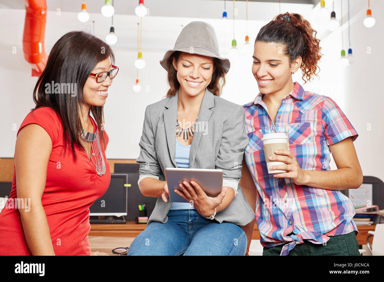 Three women in startup creative team using social media Stock Photo - Alamy