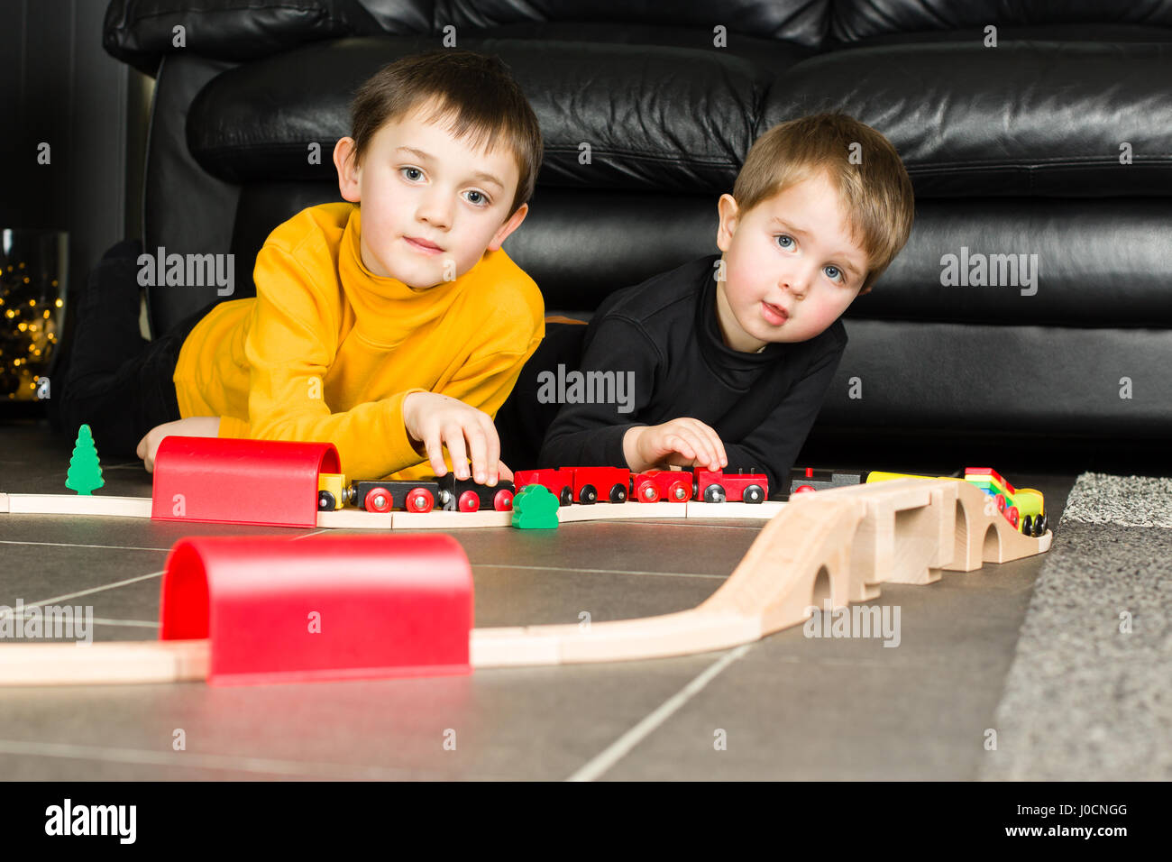 Children playing with wooden toy train. Brothers build wooden railroad ...