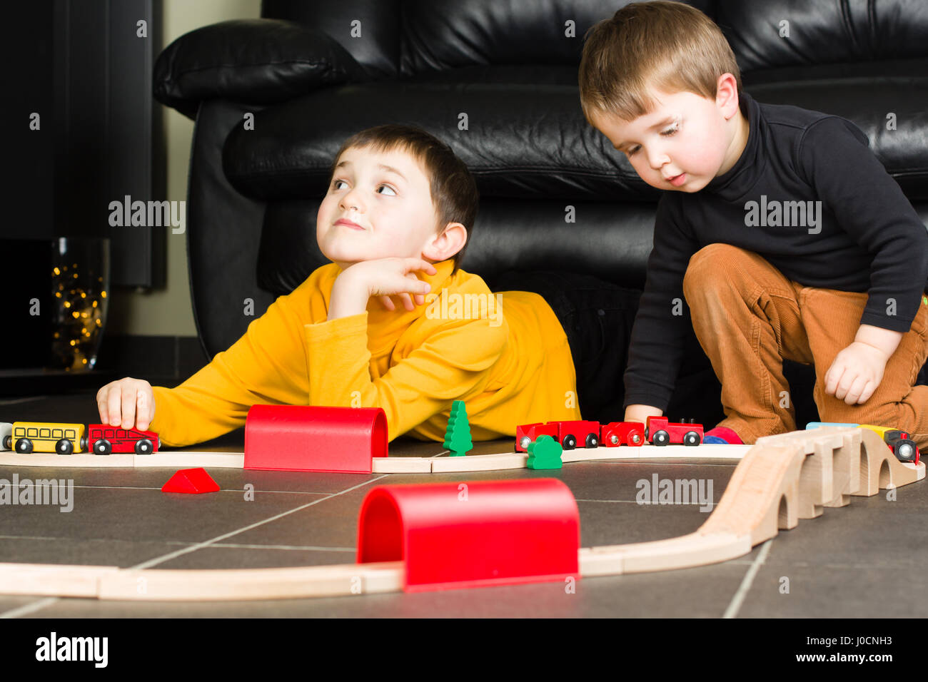 Children playing with wooden toy train. Brothers build wooden railroad ...