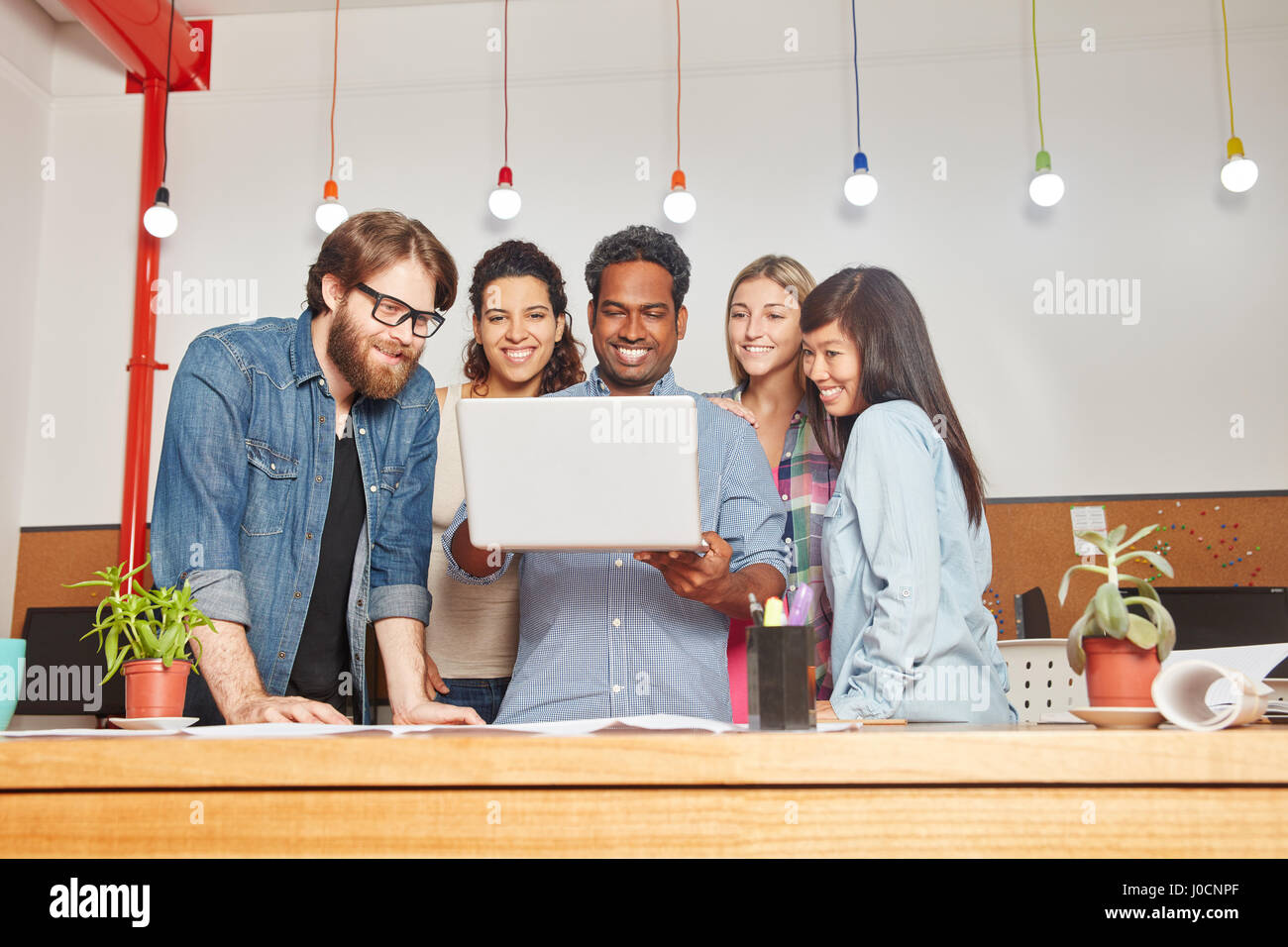 Young creative founder in successful startup team holding laptop Stock ...