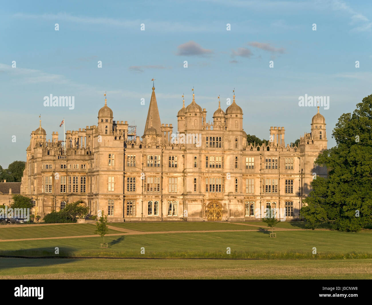 Burghley House stately home and estate grounds in warm evening light ...
