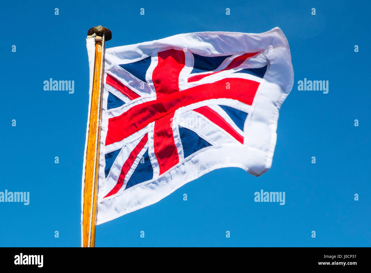 A shot of the Union Flag or Union Jack flying over a clear blue sky ...