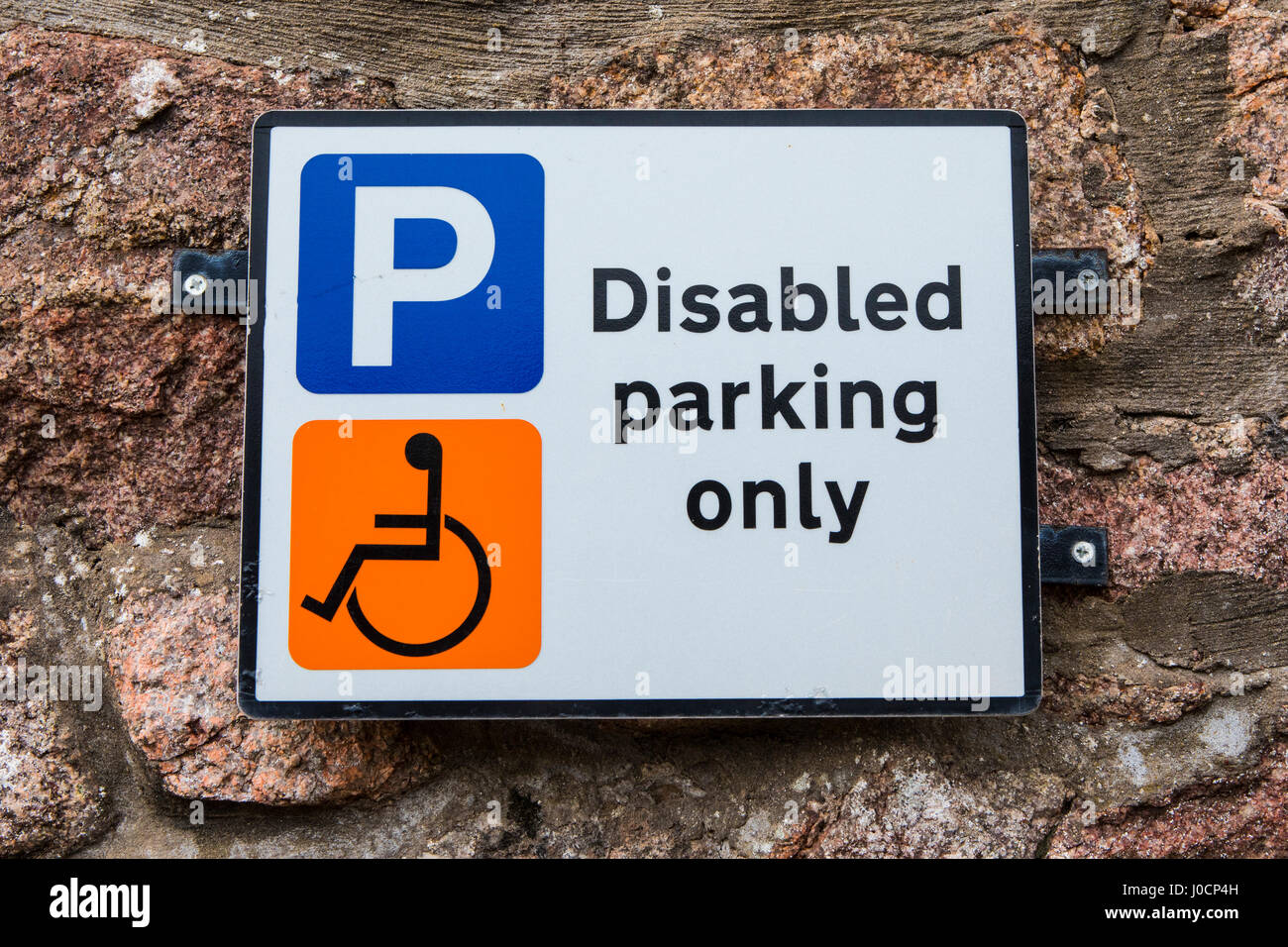 A Disabled Parking only sign attached to a wall Stock Photo - Alamy