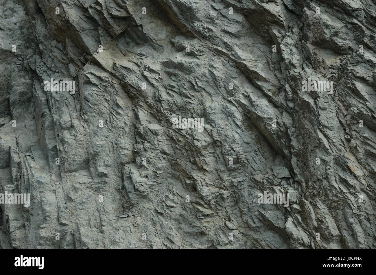 Rock vertical wall of the coastal cliff above the road in Cap Corse ...