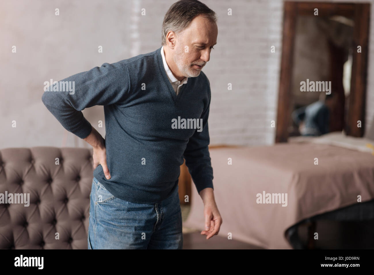 Im too old. Side view of old handsome man standing and touching his ...