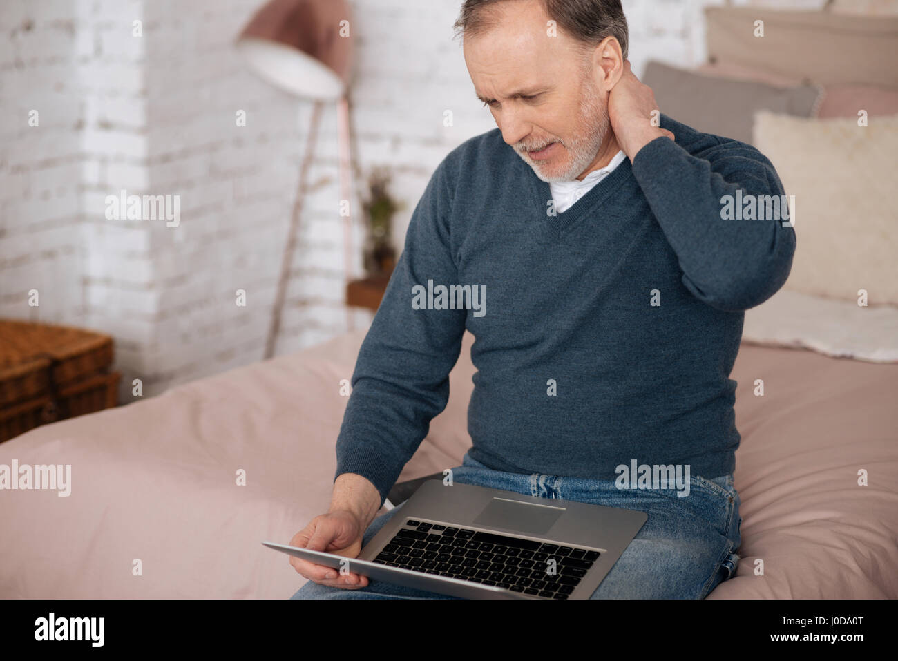 So bad ache. Old man feeling pain on neck area while sitting on bed and ...