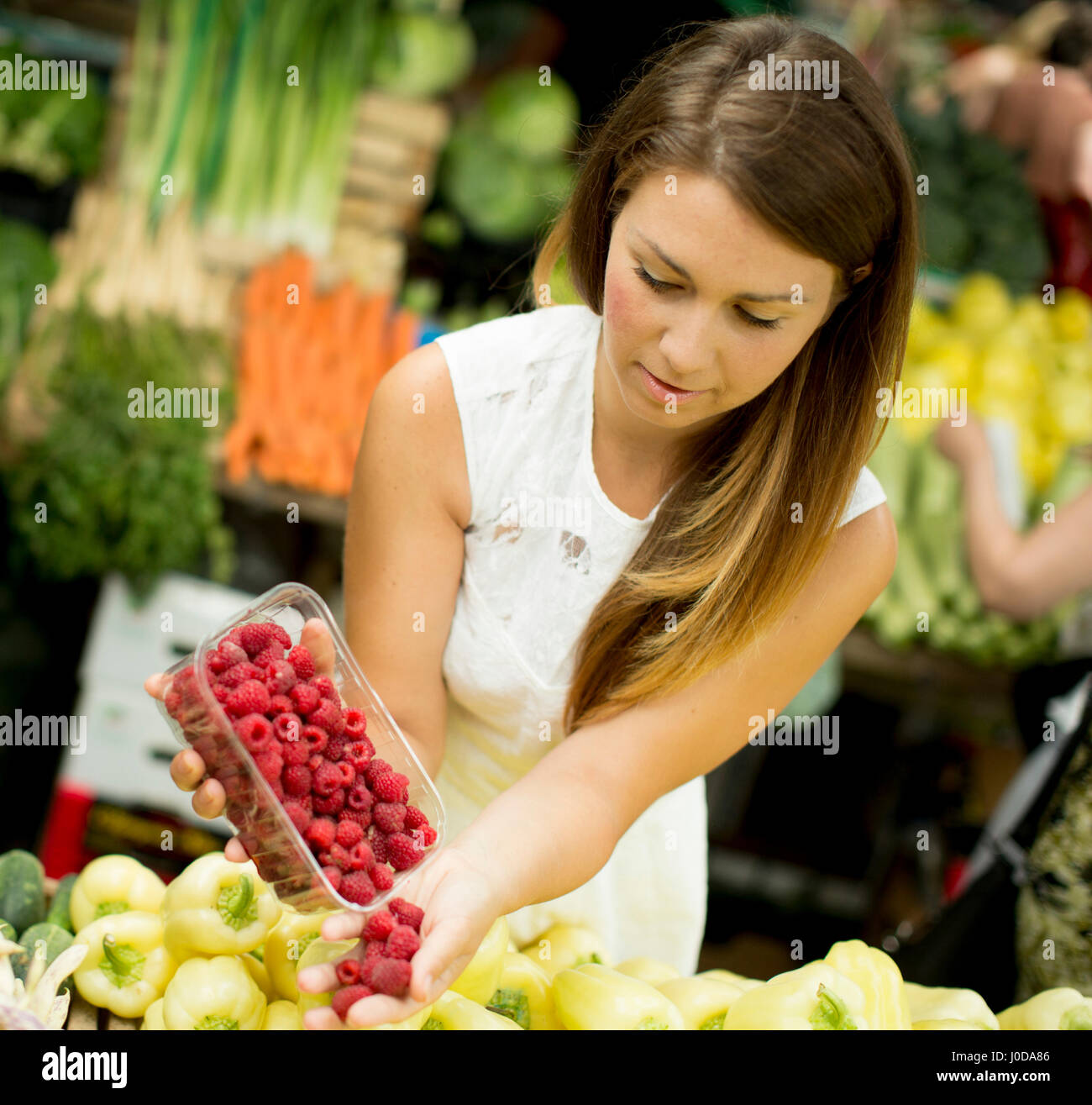 Young woman buys raspberries at the market Stock Photo - Alamy