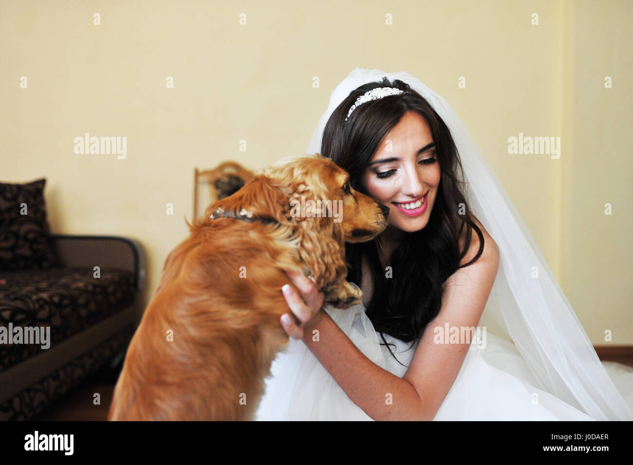 Beautiful smiling brunette bride at wedding dress at room with funny ...