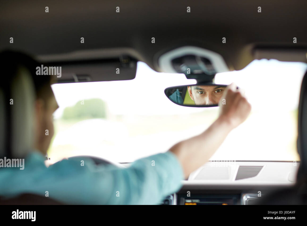 man driving car adjusting rearview mirror Stock Photo - Alamy
