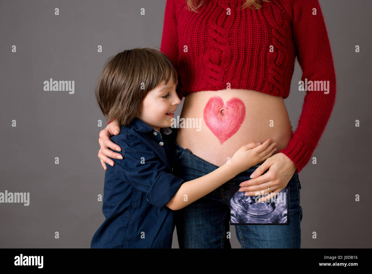 Beautiful preschool child, hugging his pregnant mom, happily expecting ...
