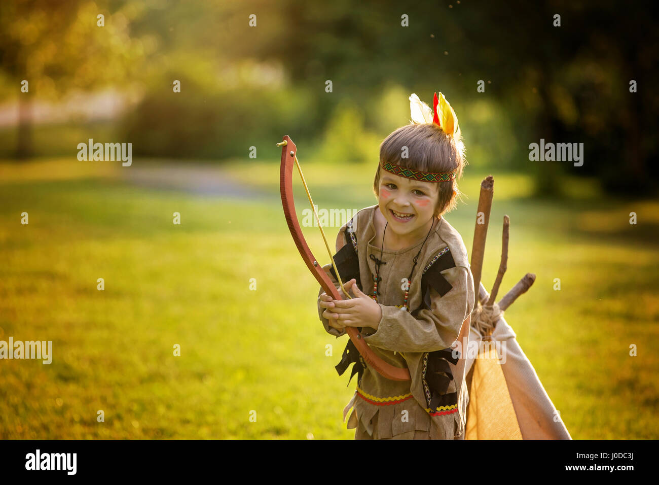 Cute portrait of native american boy with costumes, playing outdoor in ...