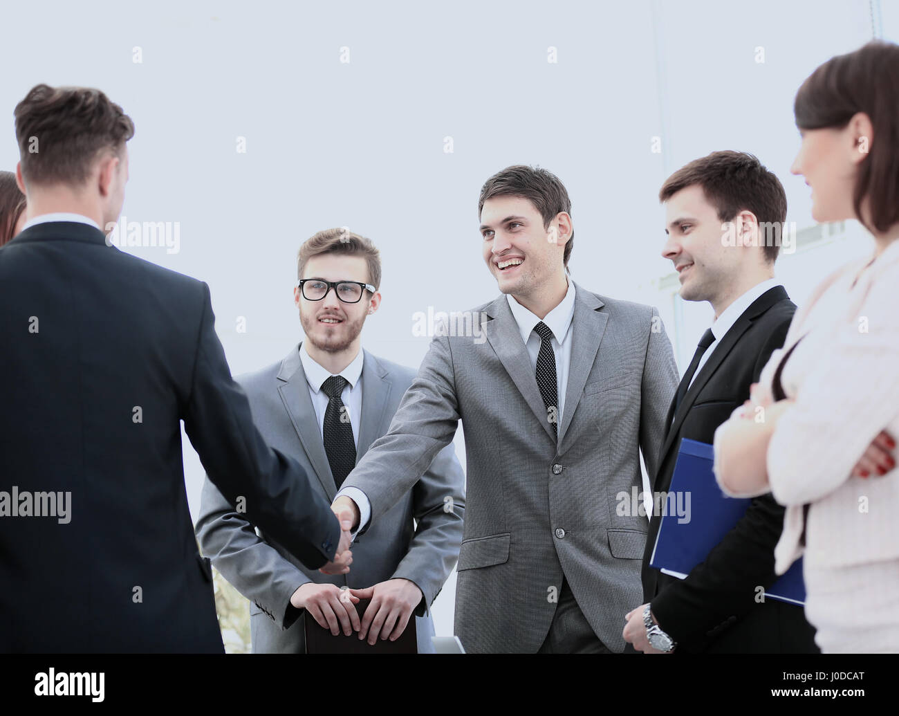 in the foreground photo: the banker and the CEO shake hands before ...