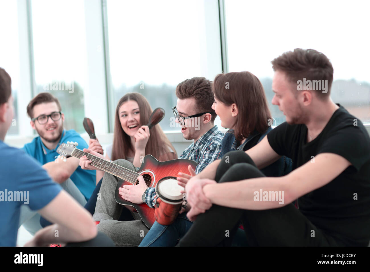 close-up of the band with a guitar sitting in the lobby of the ...
