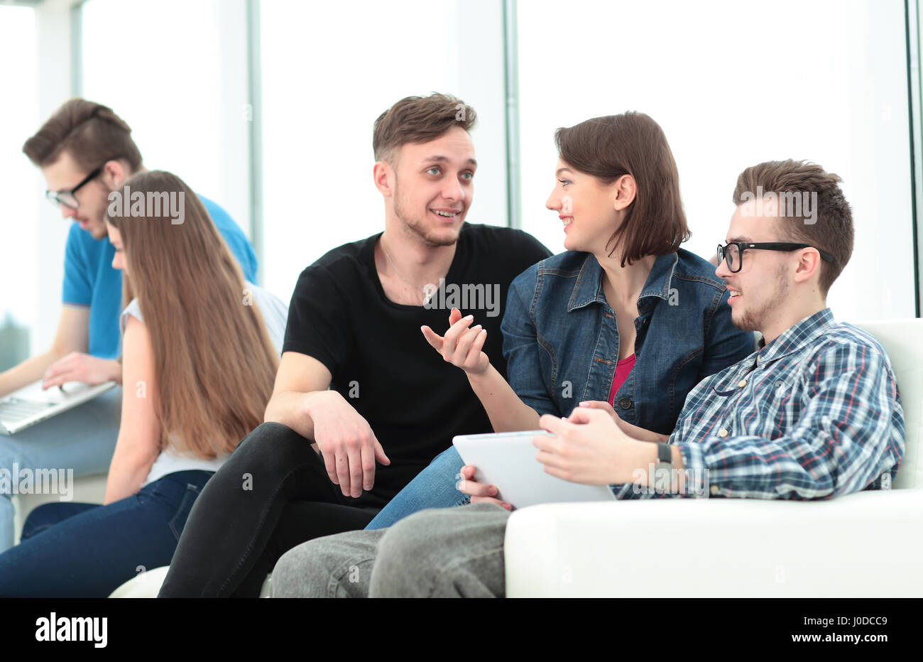 closeup of a group of students talking to each other after class in the ...