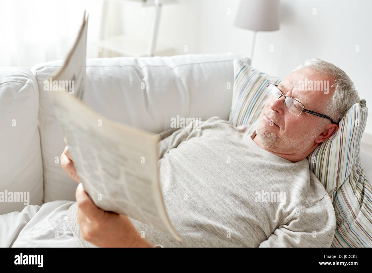 close up of senior man reading newspaper at home Stock Photo - Alamy