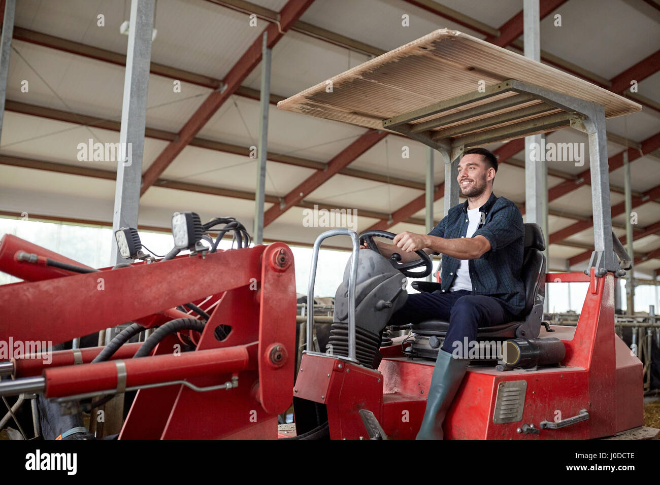 man or farmer driving tractor at farm Stock Photo - Alamy