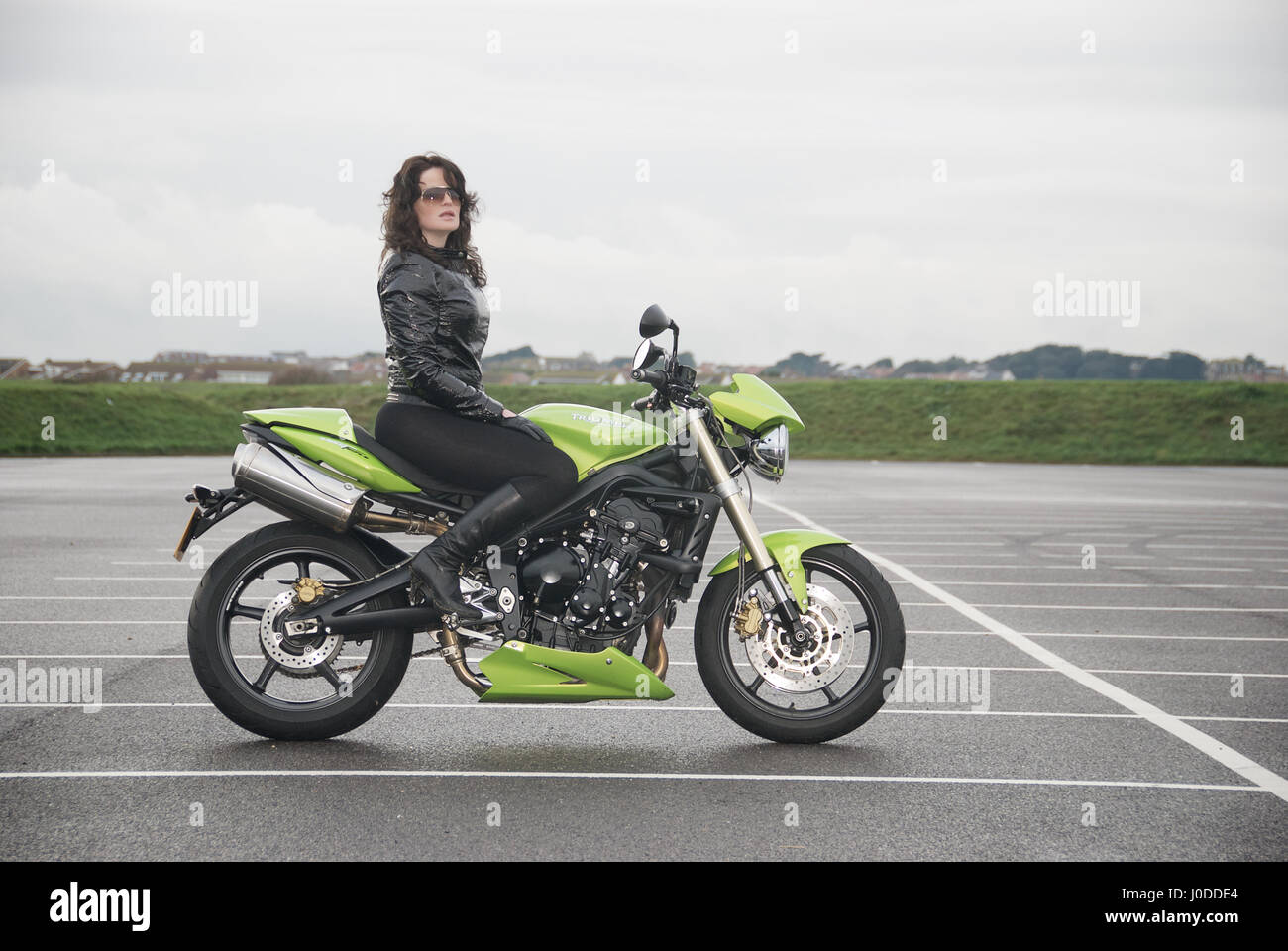 Beautiful brunette girl wearing black on a Triumph Street Triple ...