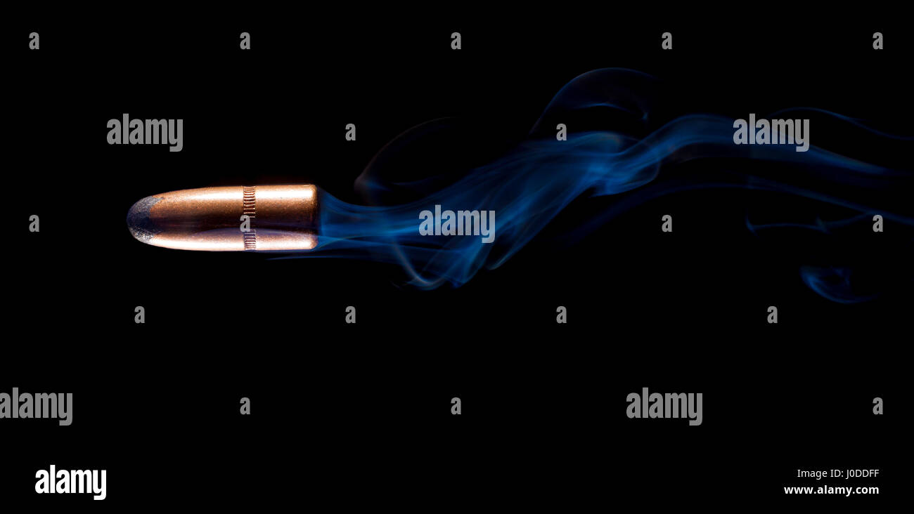 Bullet on black with lots of blue smoke behind Stock Photo - Alamy