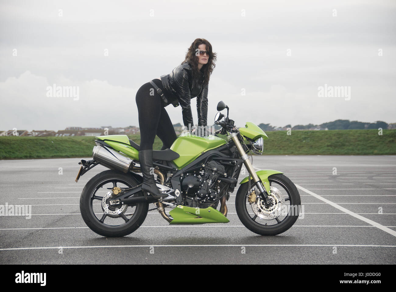 Beautiful brunette girl wearing black on a Triumph Street Triple ...