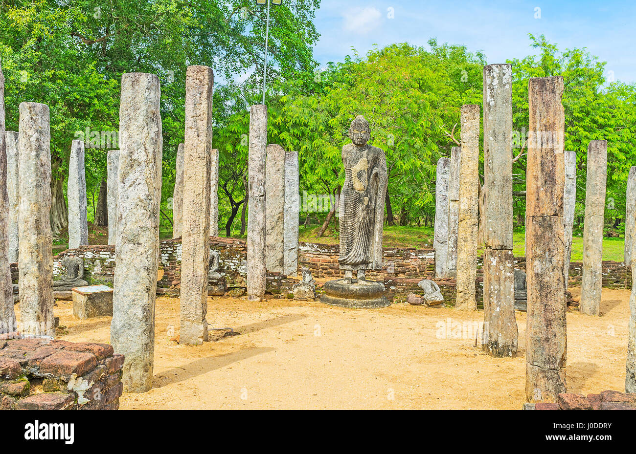 The statue of Lord Buddha, surrounded by stone pillars in ancient ...