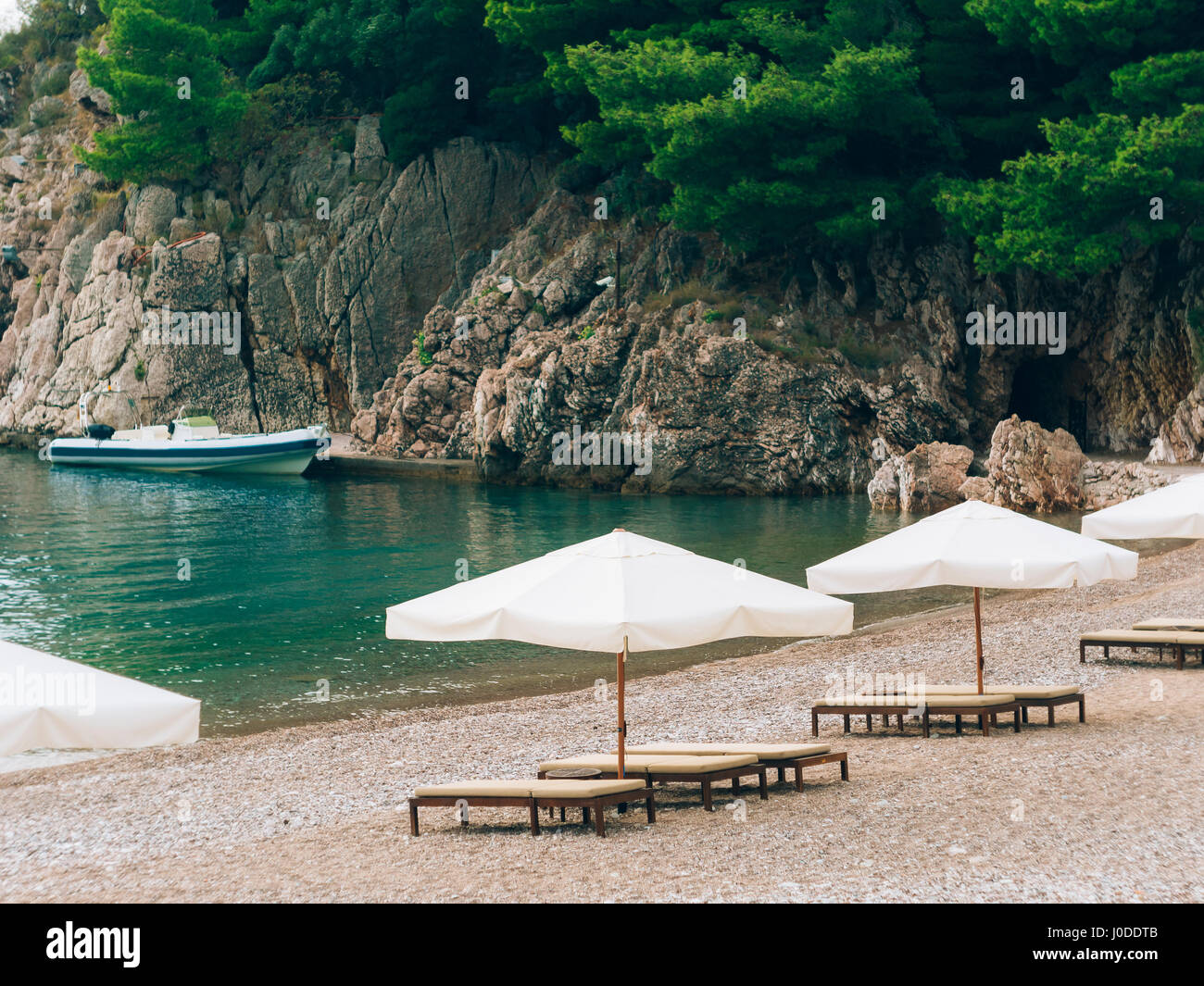 Sun beds and umbrellas on the beach. Montenegrin beaches of the Stock ...