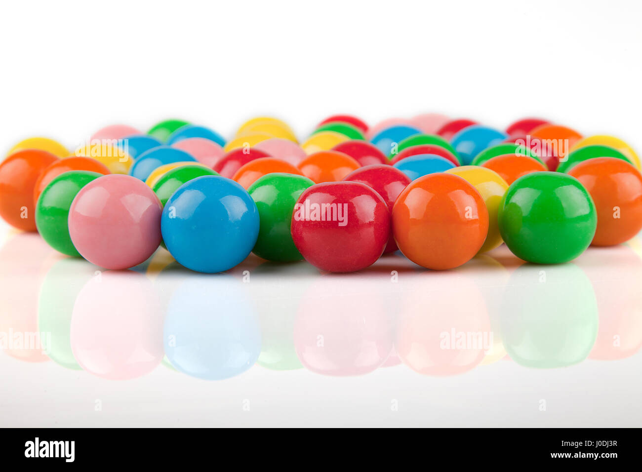 Multicolored gumballs on a white surface. Bubble gums isolated on white ...