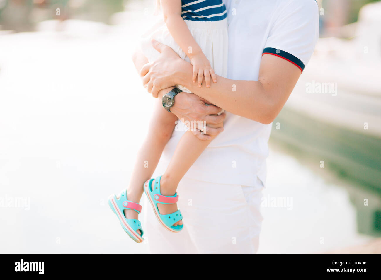 Parents hold the child in their arms. A little child with parent Stock ...