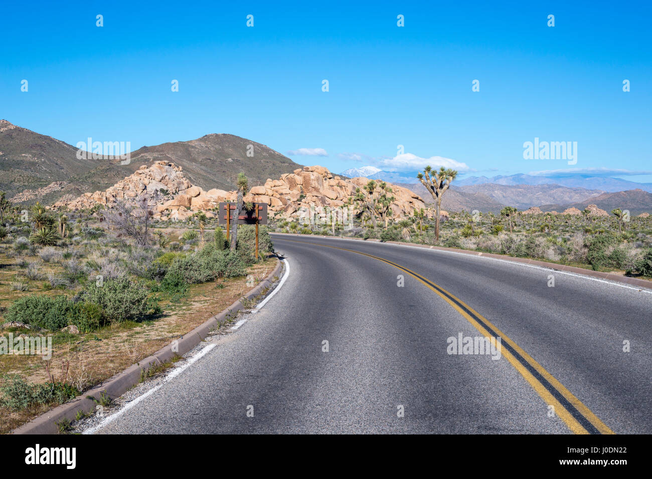 Desert landscape and road running through Joshua Tree National Park ...