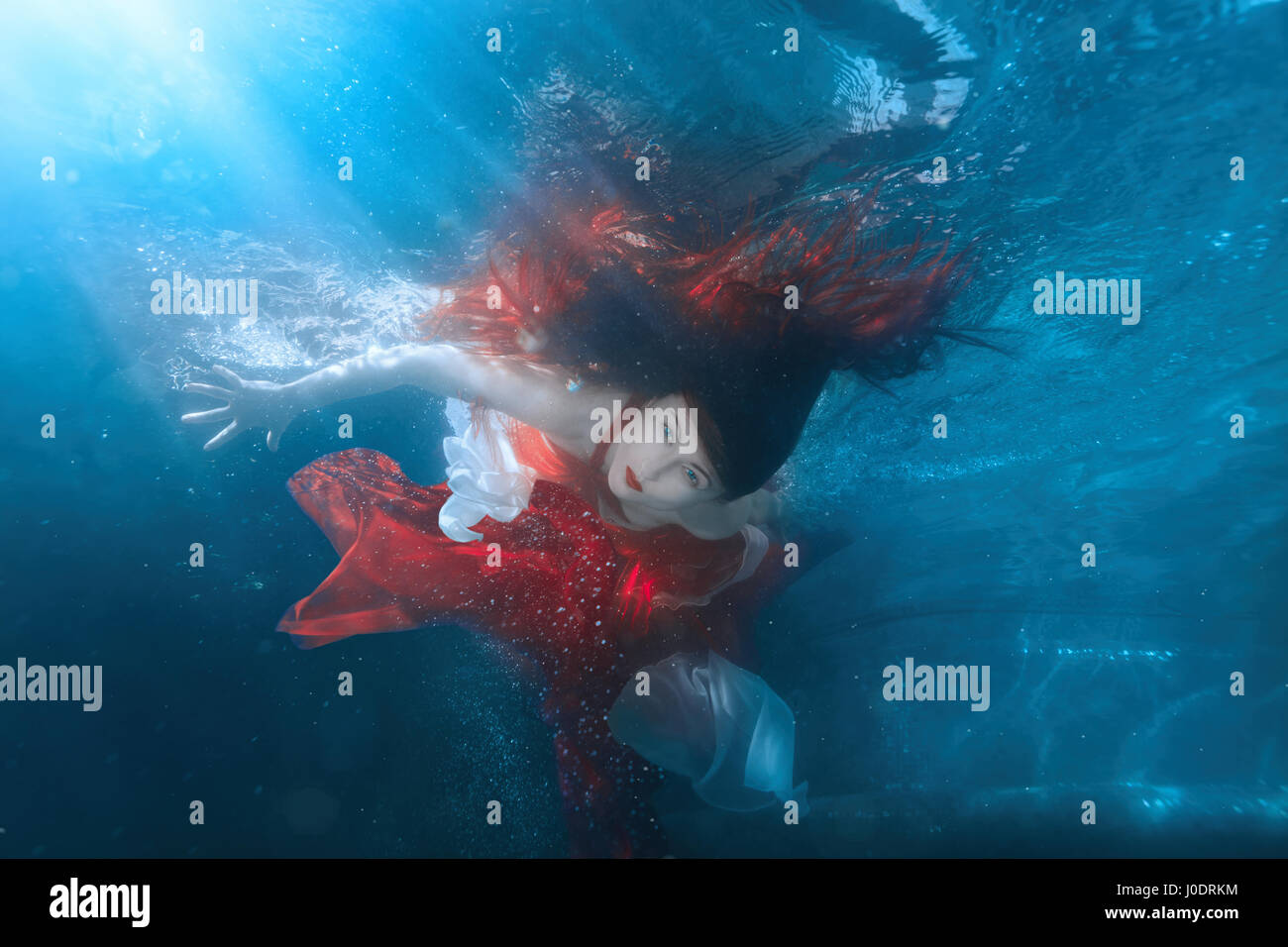 Girl in red dress under water, it is a mermaid Stock Photo - Alamy