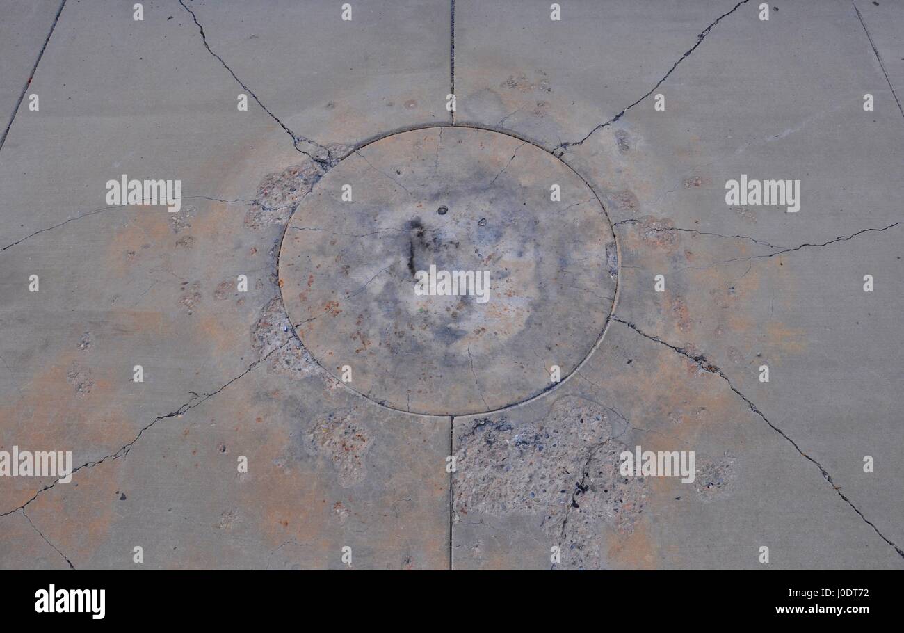 cracks in the cement create a circular pattern with additional fissures ...