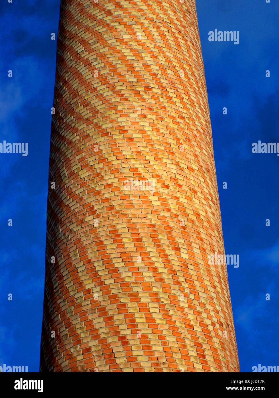 a cylindrical brick tower rises up, its red and yellow construction ...