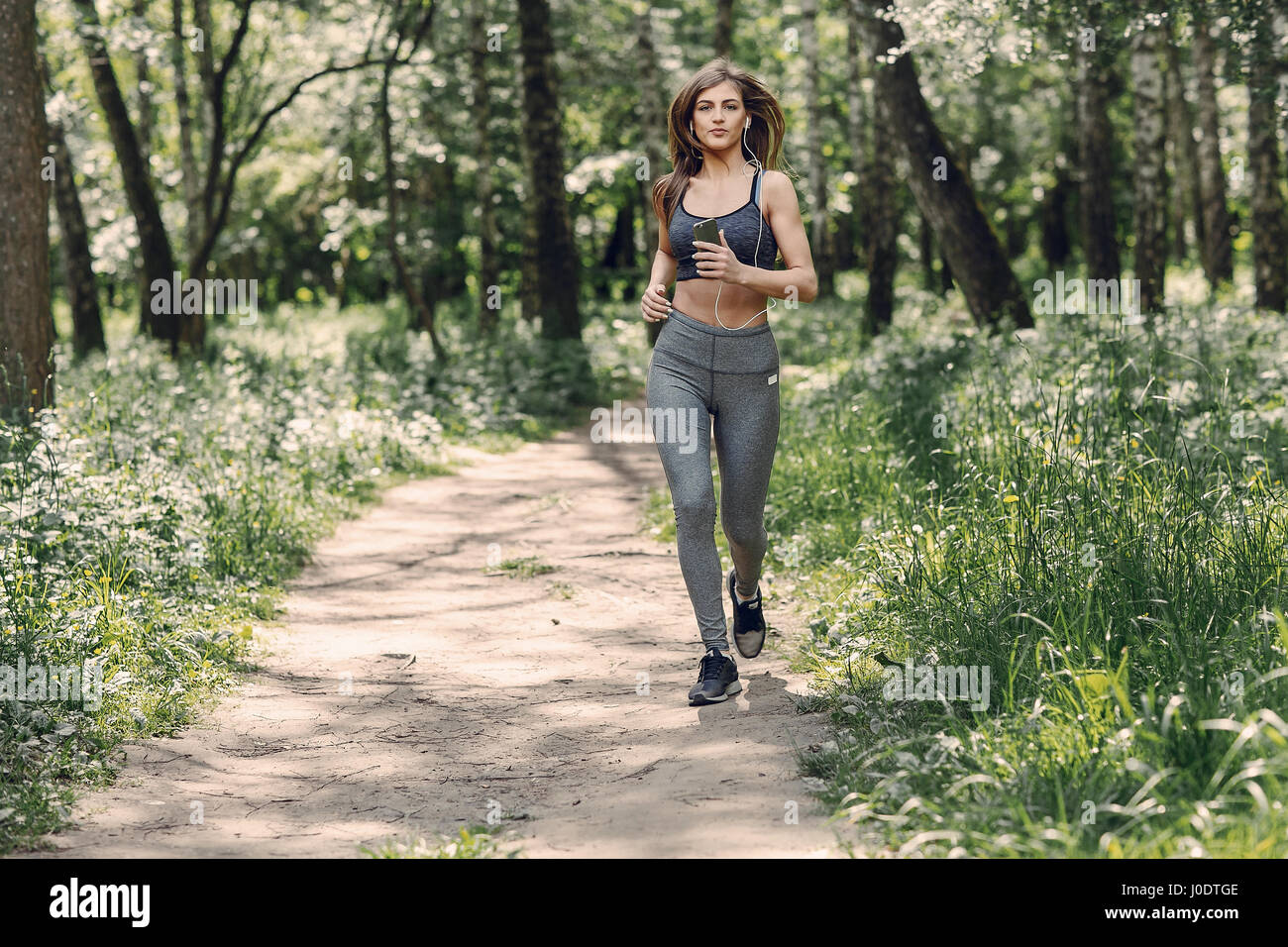athletic girl running in the Park and doing exercises Jogging Stock ...